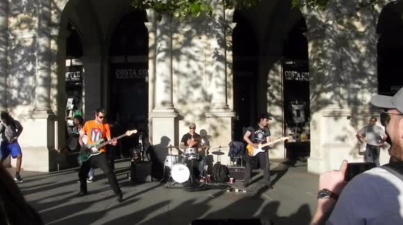 Busking heavy rock band entertain the crowds on the corner of the ...