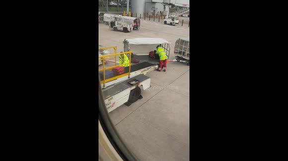 Baggage handlers at Manchester Airport toss suitcases over cart - Buy ...