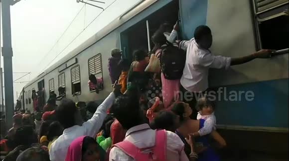 Train passengers fight to get into incredibly crowded train in India ...