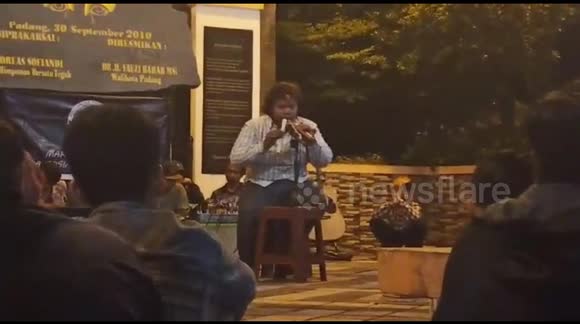 a young man played 2 pianika inflatable instruments and Minangkabau ...