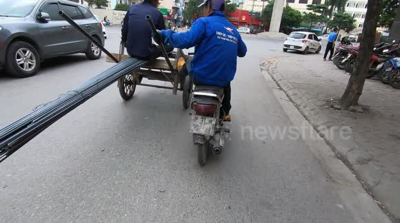 Extraordinary moment! A man driving a motorbike uses one leg to push a ...