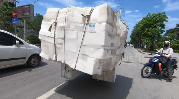 Overload motorcycles carry a lot of foam boxes three stories high and ...