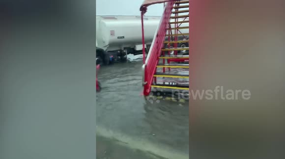 Airport bus drives passengers across flooded tarmac after tropical ...