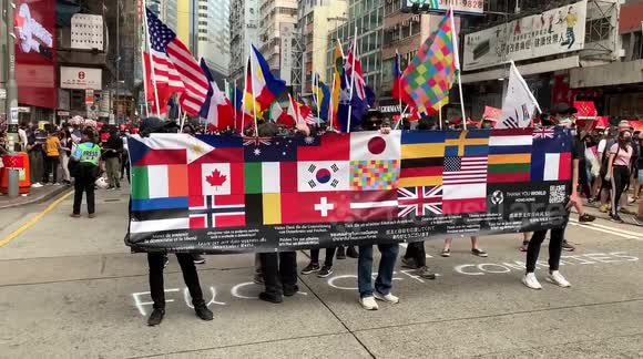 Protesters hold flags of world as they protest against "totalitarianism ...