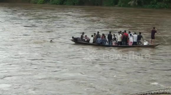 Terrifying moment Indian boatman plunges into flooded river but manages ...