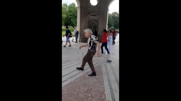 Cheerful and energetic grandpa shows off his dancing moves in a court ...