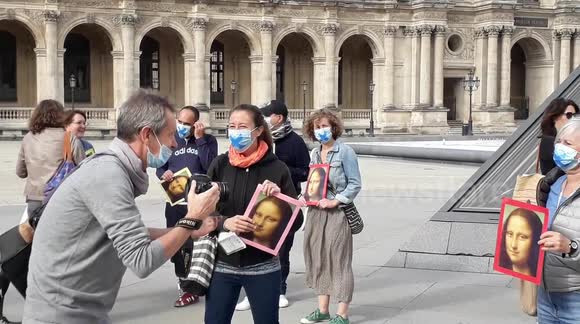 Tour guides hold Mona Lisa portraits as they protest during reopening ...