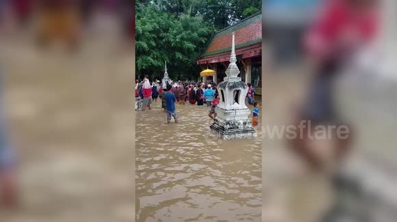 Buddhist worshippers perform religious ceremony at flooded temple in ...