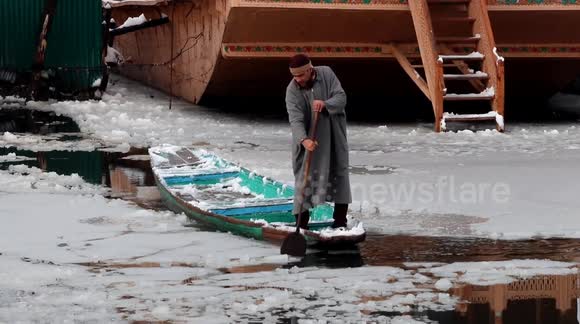 Local boatman force their way across frozen lake after heavy snowfall ...
