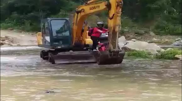 Digger transports residents through deep floodwater due to heavy rain ...
