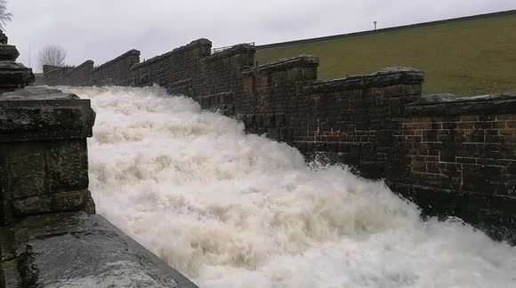 Torrent flows down overflow channel of reservoir near Wardle, UK ...