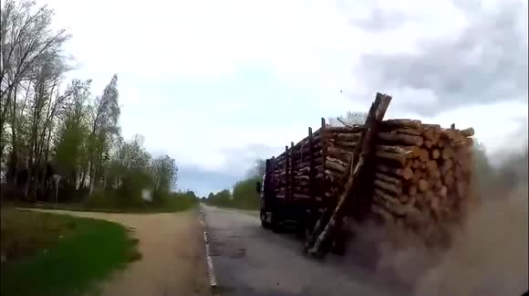 Quick-thinking driver swerves to avoid logs falling from a timber truck ...
