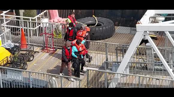 Migrants walking up the ramp at the port of Dover after being unloaded ...