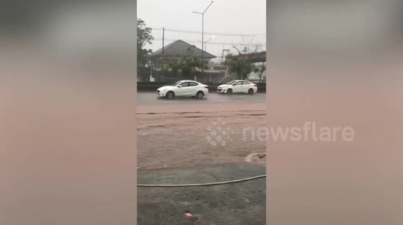 Drivers battle through flooded road during monsoon season storm in ...