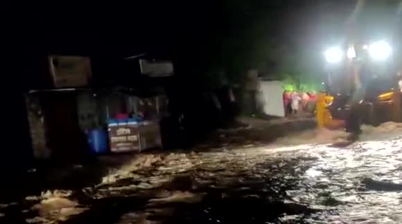 Locals rescued in a digger from raging floodwaters as heavy rain ...