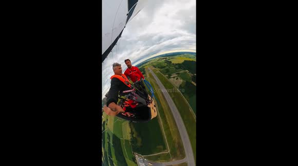 Adventurous man bungee jumps from hot air balloon floating above ...