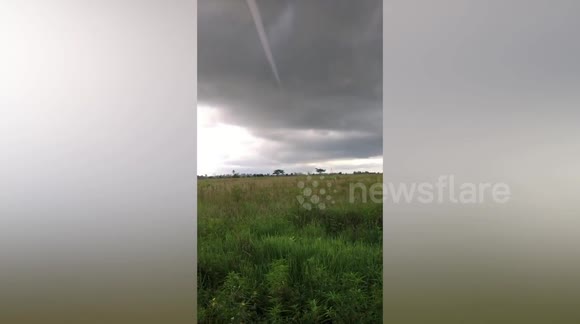 Terrifying funnel cloud appears over field as landspout tornado swirls ...
