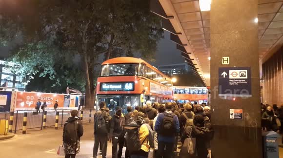 Londoners crowd at bus stops outside Euston station during evening rush ...