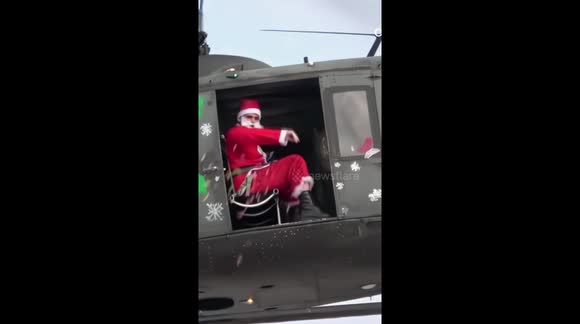 Airborne Santa flying in a military helicopter and delivers candies to ...
