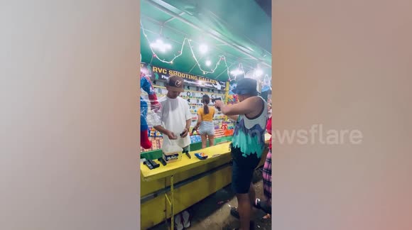 Competitive fairgoer shoots all balls at firing range booth in the ...