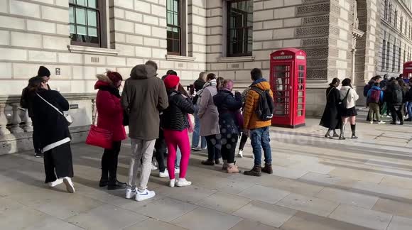 Tourists form huge queues to take photos with an iconic red telephone ...