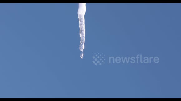 A single ice cycle hanging from a roof melting in the sunshine. - Buy ...