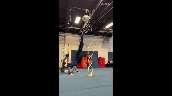 Acrobat tries to go through a ring during stunt practice *Gymnastic ...