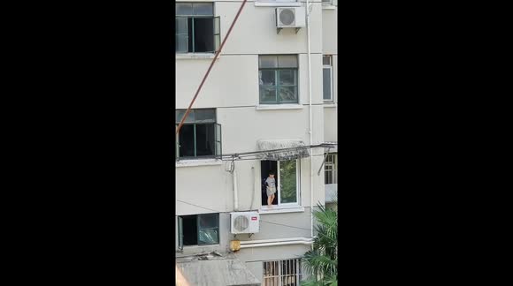 Terrifying scene as young boy walks along narrow 1st-floor window ledge ...