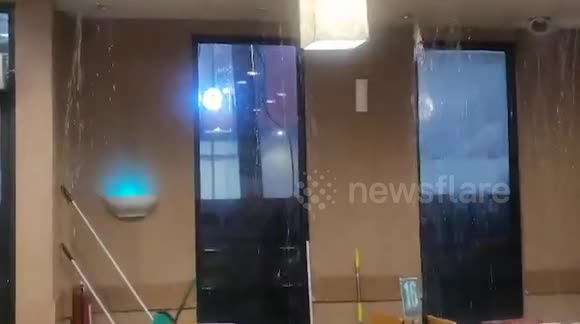Rain pours into restaurant through ceiling during monsoon storm in the ...