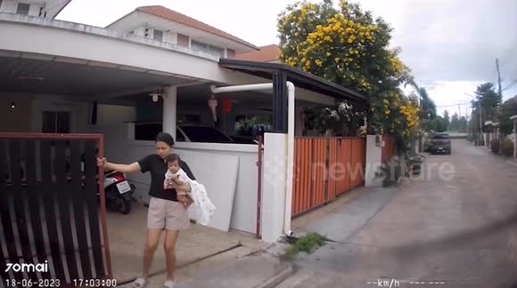 Sliding metal gate falls over while mother carries baby in her arms ...