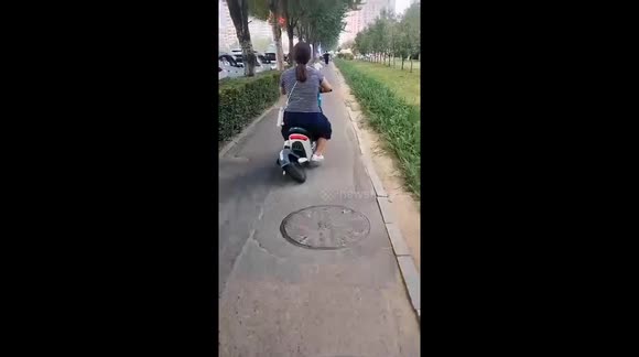 Woman rides wonky e-bike along path in China - Buy, Sell or Upload ...