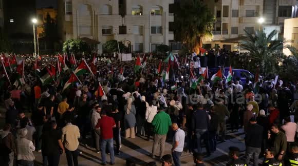 People gather near the Israeli embassy in Amman, Jordan to show support ...