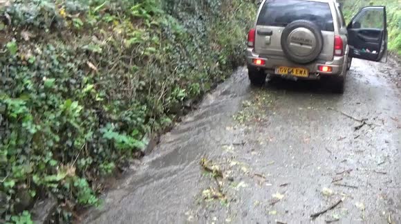 Storm Ciaran causes flooding , the rain is pouring over a slate wall ...