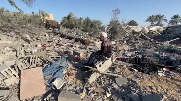 Palestinian Residents inspect around the rubble of the building ...
