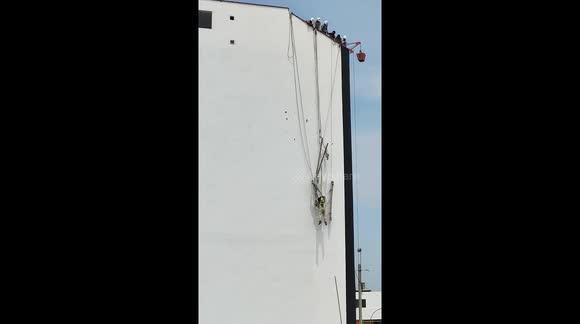 Construction worker hanging off building tangled in netting rescued in ...