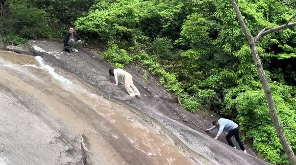 Men desperately try to rescue woman stuck on steep waterfall in China ...