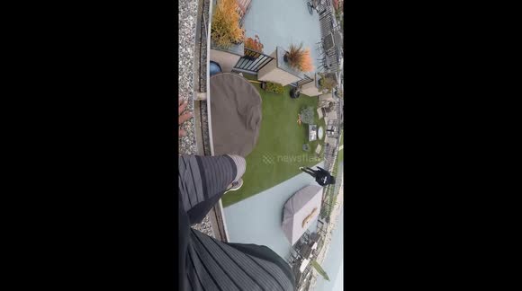 two guys stand on ledge, one jumps into pool from 5 stories up, other ...
