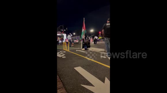 USA: A Palestine supporter watches the protest on the Watergate Hotel ...