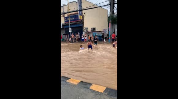 Children play in floodwaters caused by typhoon Gaemi in Cainta, Rizal ...