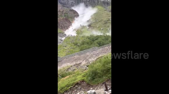 Bystanders watch on in shock as huge boulders crash down mountain at ...