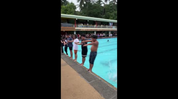 Holidaymakers perform playful domino dive stunt at pool - Buy, Sell or ...