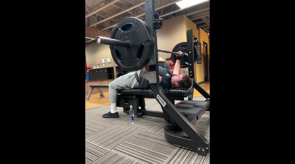 Young man breaking arm while doing bench press in the gym at night ...