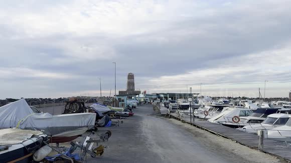 Zoom in towards the old lighthouse through the small port of Fiumara ...