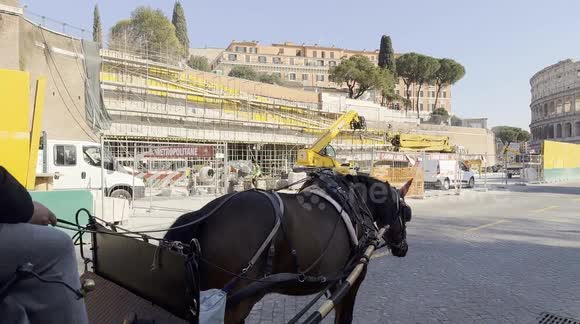A botticella, a horse-drawn carriage, travels along via dei Fori ...