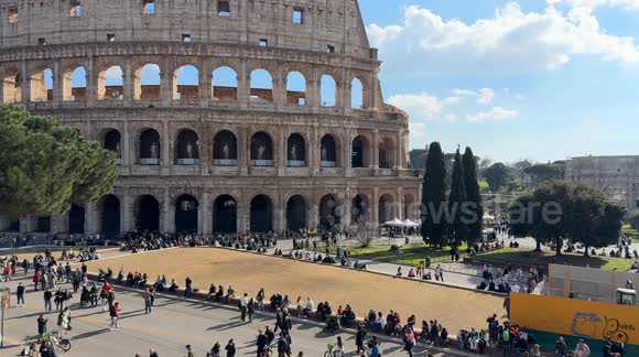 Wide shot of the Colosseum square with tourists without the barriers of ...
