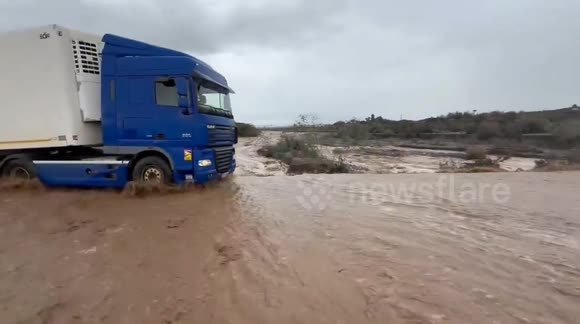 Truck powers through flooded road as Storm Laurence hits Spain - Buy ...