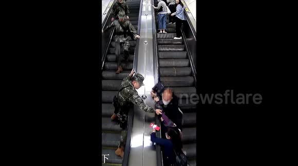 Armed police leap onto escalator to rescue falling elderly person in ...