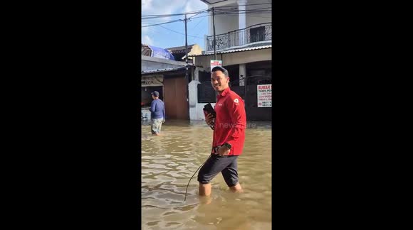 News reporter stands in knee-deep floods in Indonesia - Buy, Sell or ...