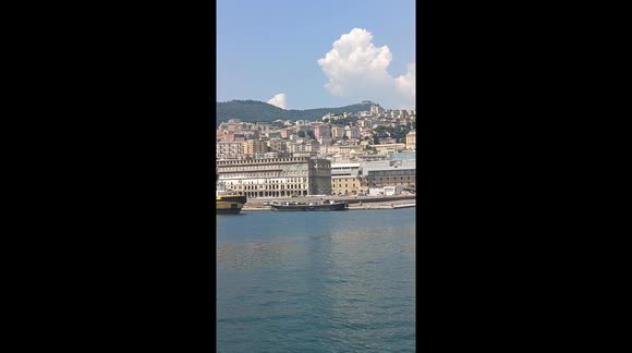 Genoa, Europe, vertical POV from tourist boat cruising through historic ...